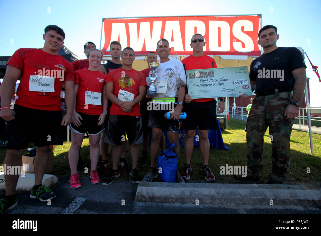 The Marine Aviation Logistics Squadron 14 Honey Badgers stand holding ...