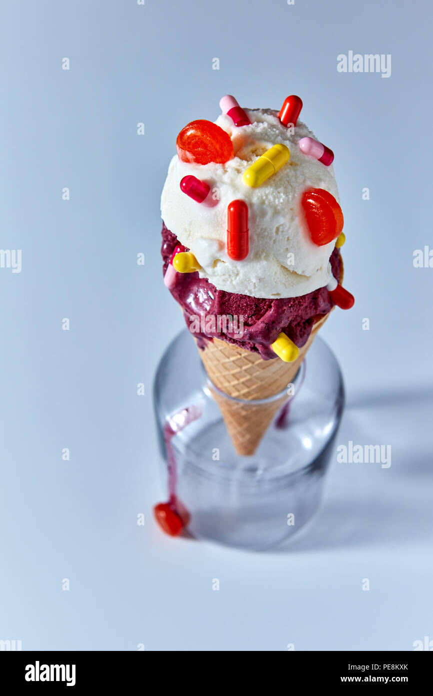 Waffle cone with different ice cream balls decorated with capsules of ...