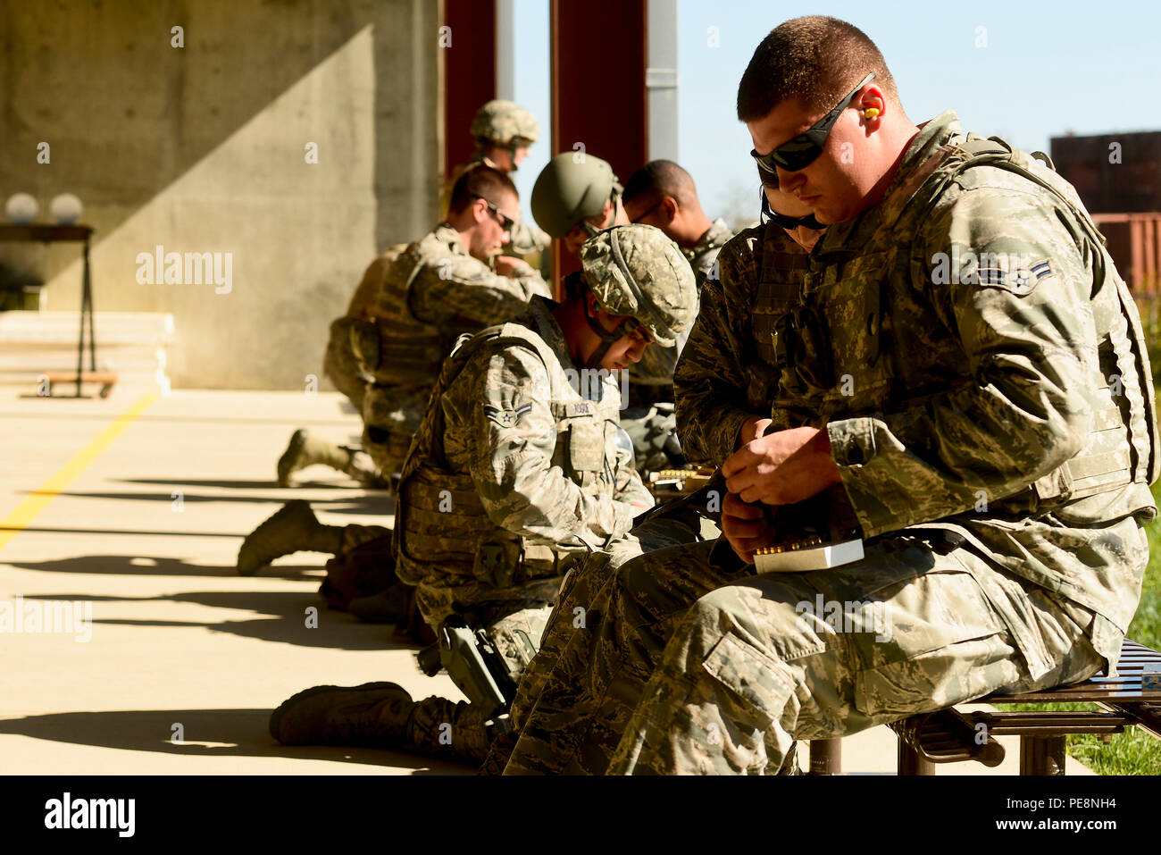 U.S. Air Force Airmen load magazines with 9 mm rounds before qualifying ...