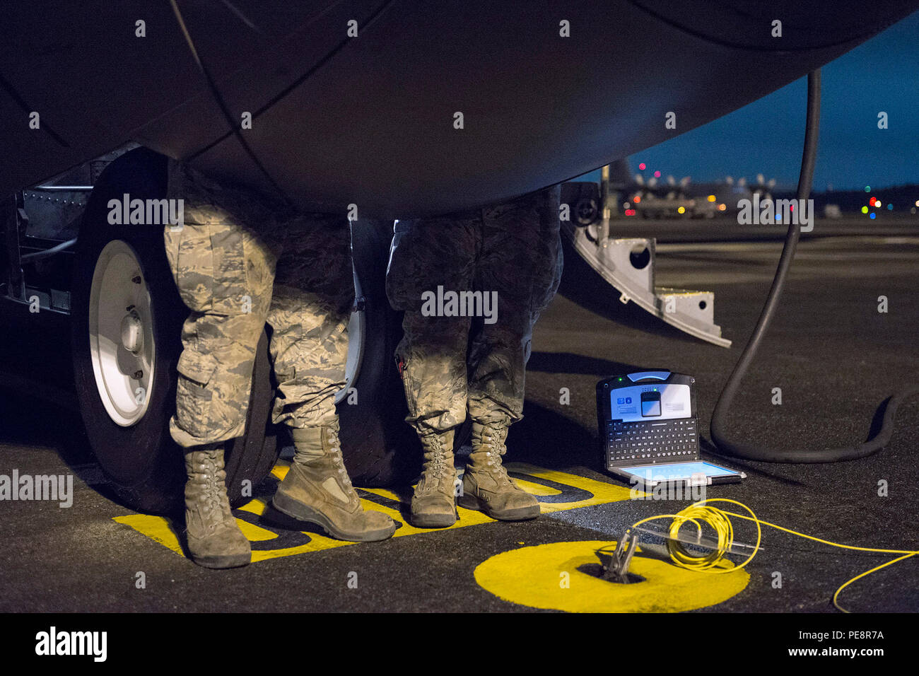 Airmen with the 374 Aircraft Maintenance Squadron inspect landing gear ...