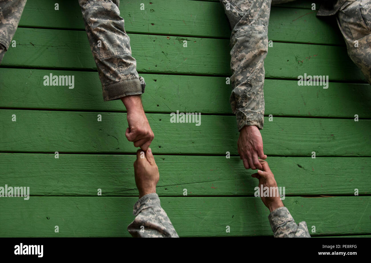 A Soldier's fingers slip throug his teammates' grasp as they try to ...