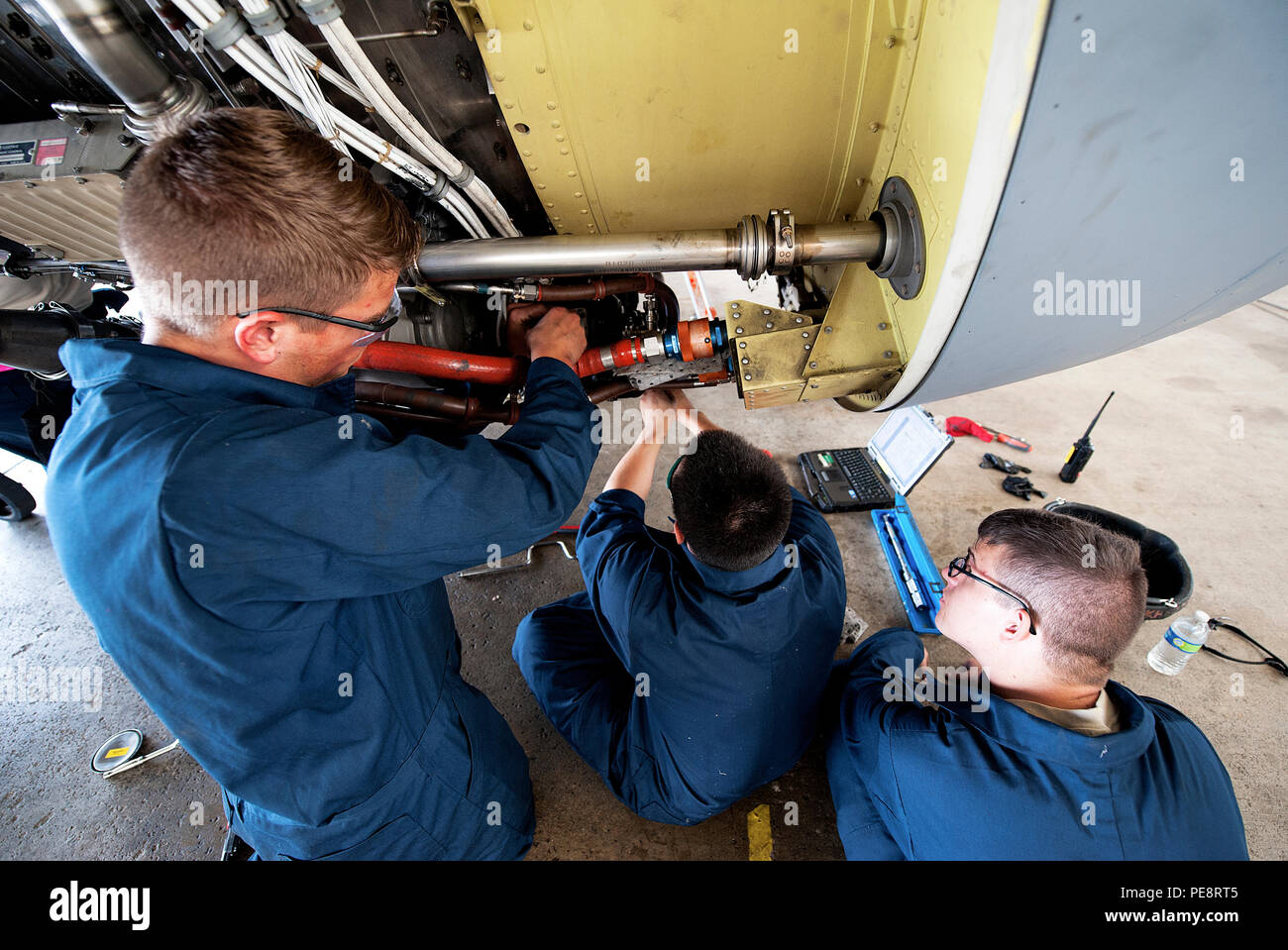 Airmen from the 909th Aircraft Maintenance Unit work on an F108 engine ...