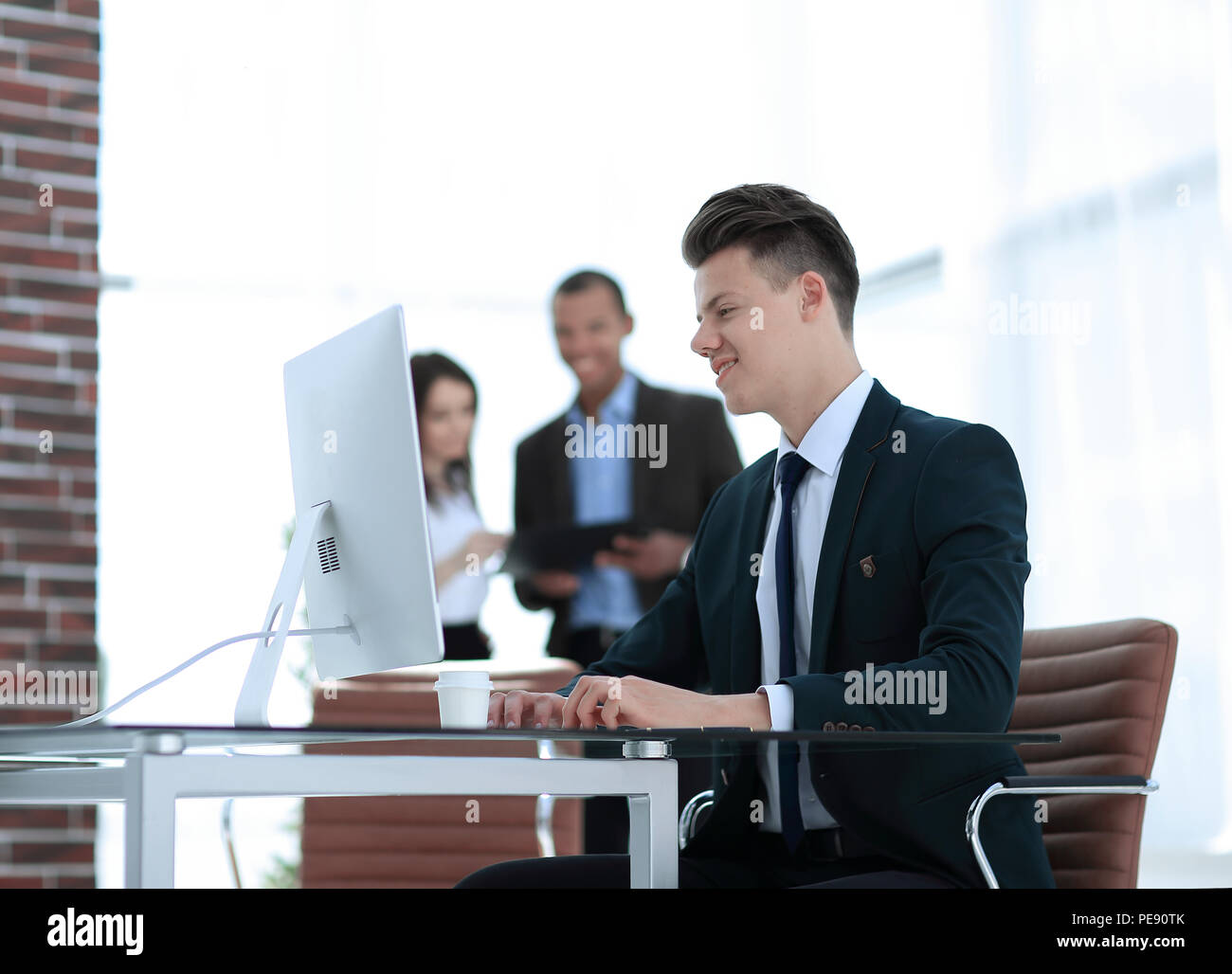 employee sitting behind a Desk in the office Stock Photo - Alamy