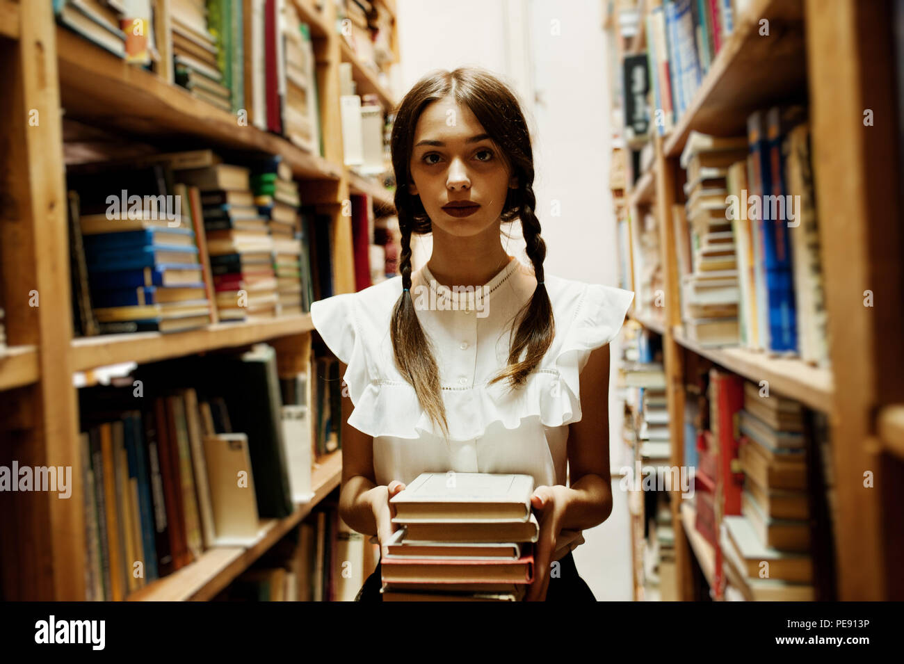 Girl with pigtails in white blouse at old library Stock Photo - Alamy