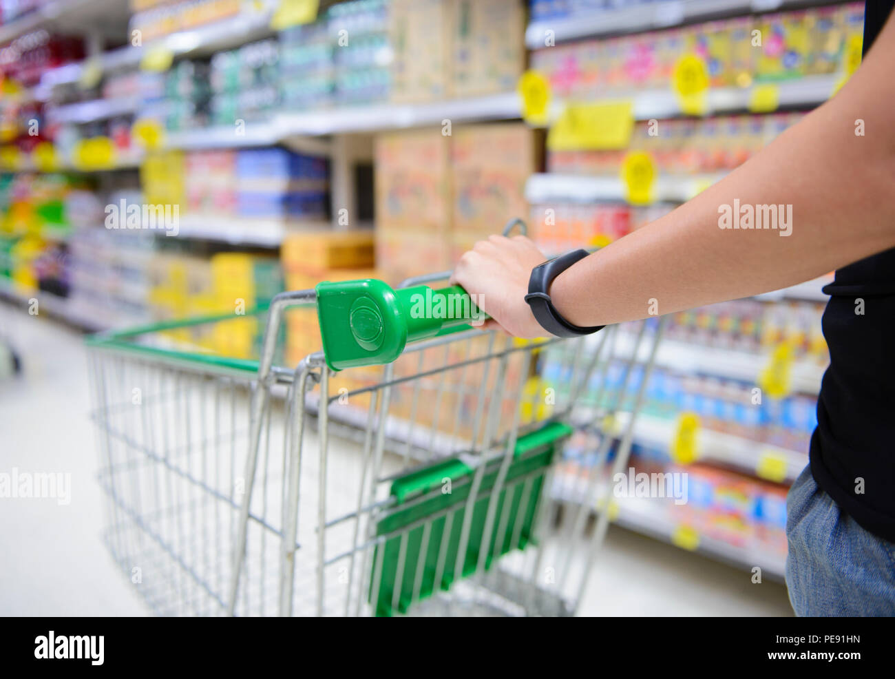 Closeup hand pushing shopping cart in groceries store Stock Photo - Alamy