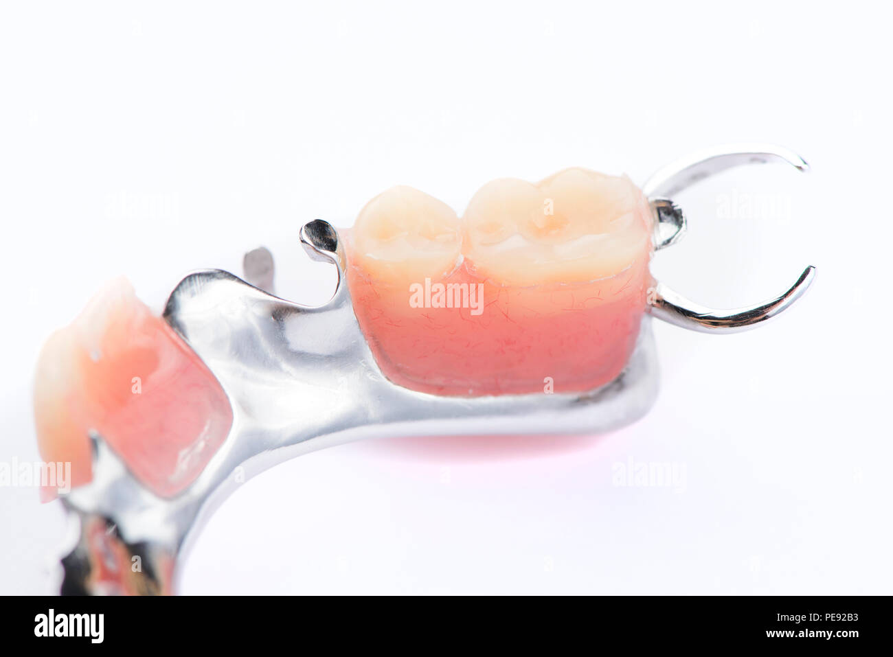 Close-up lower metal denture on a white background Stock Photo - Alamy
