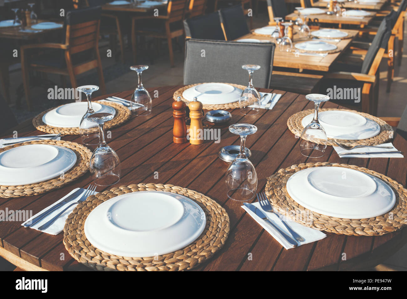 Circle wooden table setting in restaurant terrace Stock Photo - Alamy