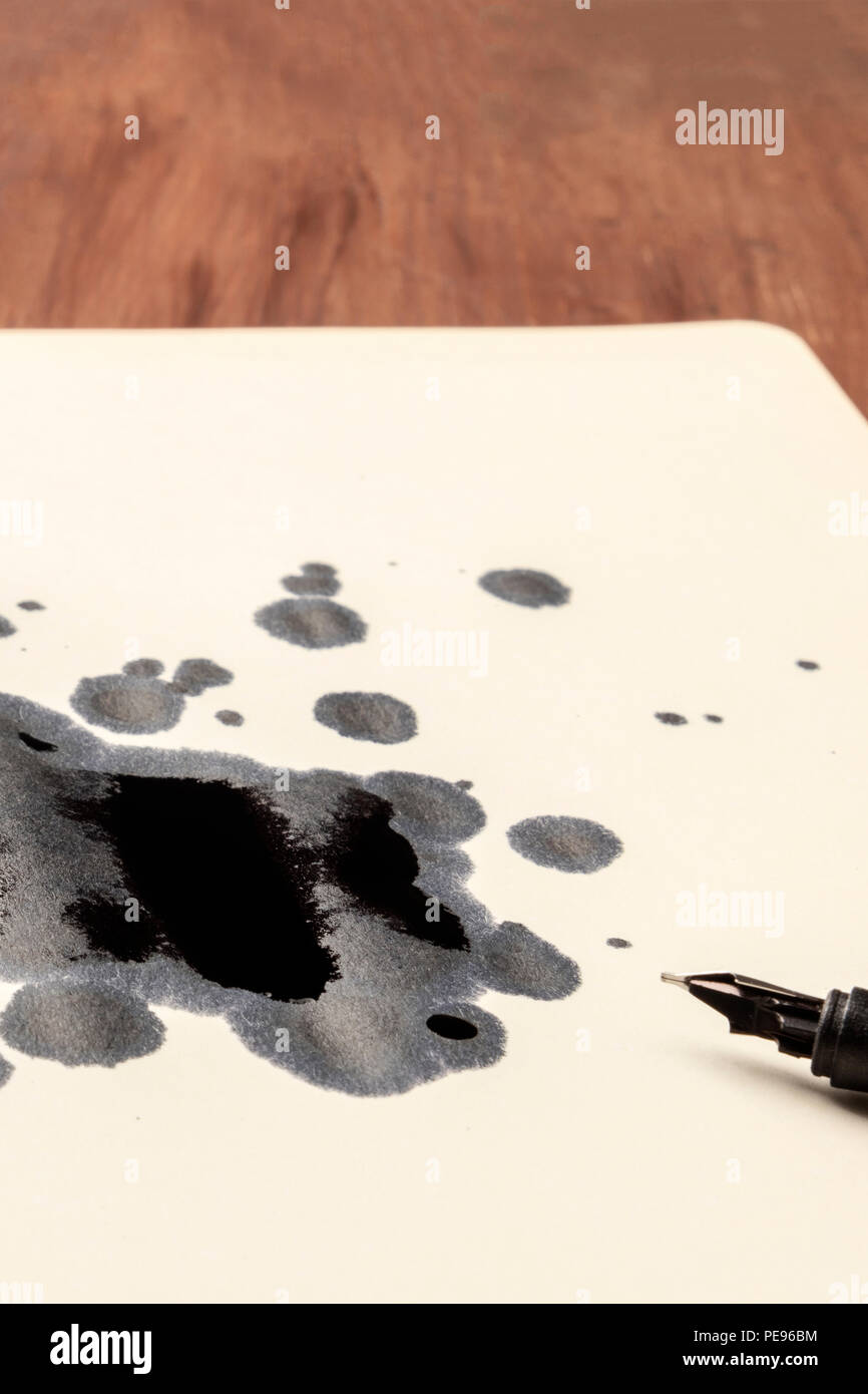 A photo of drops of ink on a sheet of textured off-white paper, with a ...