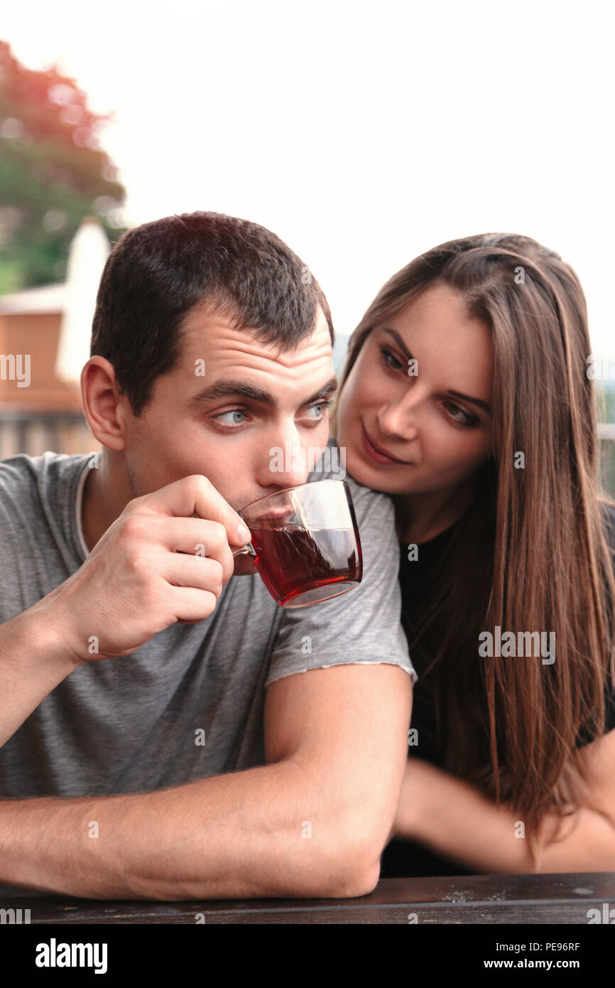 Young beautiful couple share tea at garden table Stock Photo - Alamy