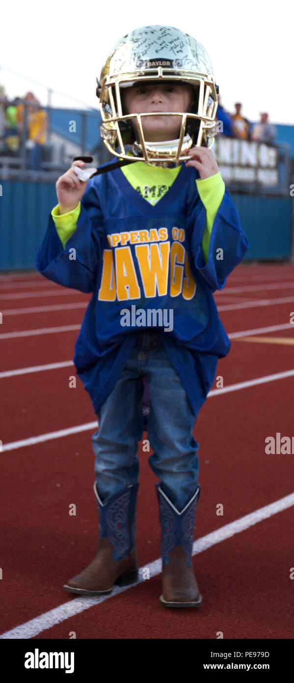 Connor Hedge stands with a football helmet signed by members of the ...