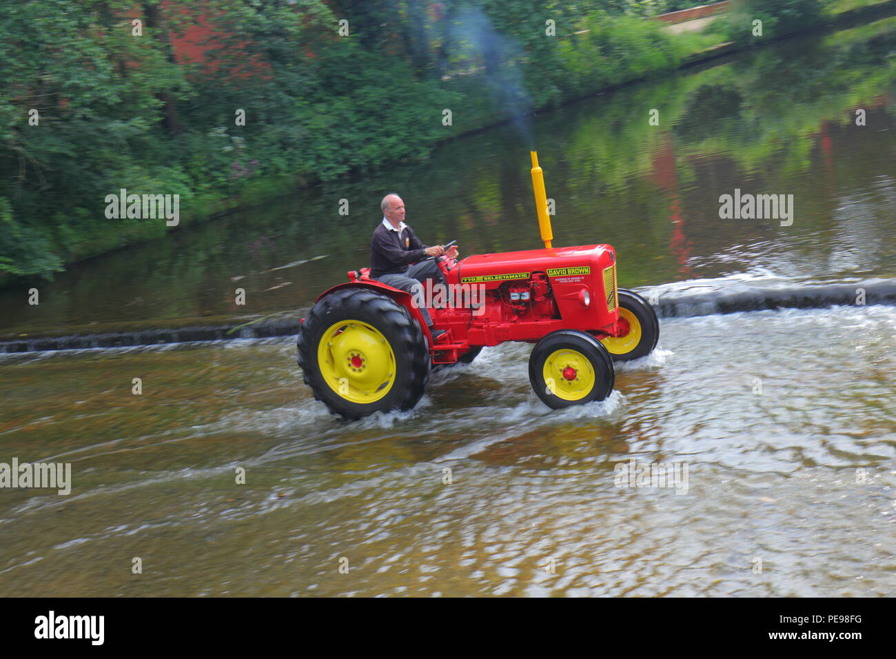A David Brown tractor crosses the River Skell with other tractors as ...