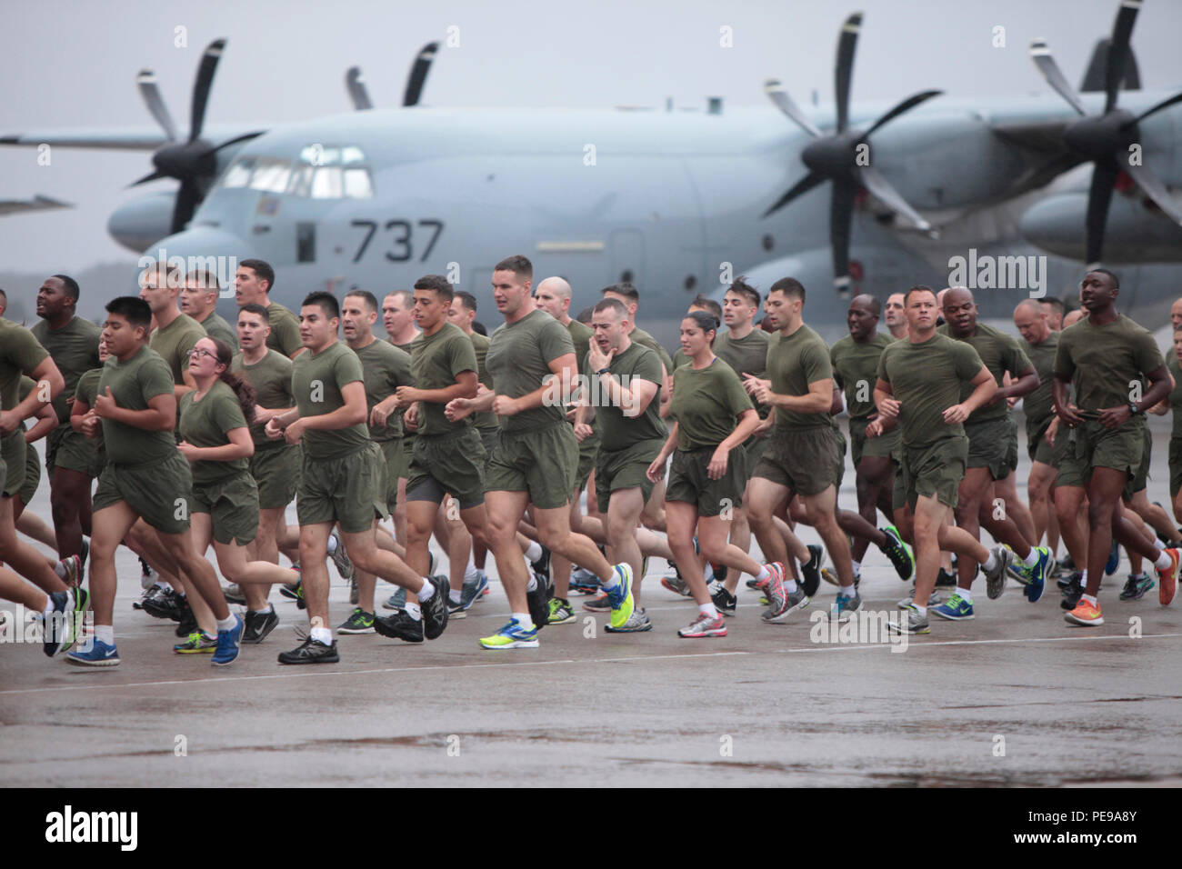 Hundreds of Marines run across the flight line during the Marine Corps ...