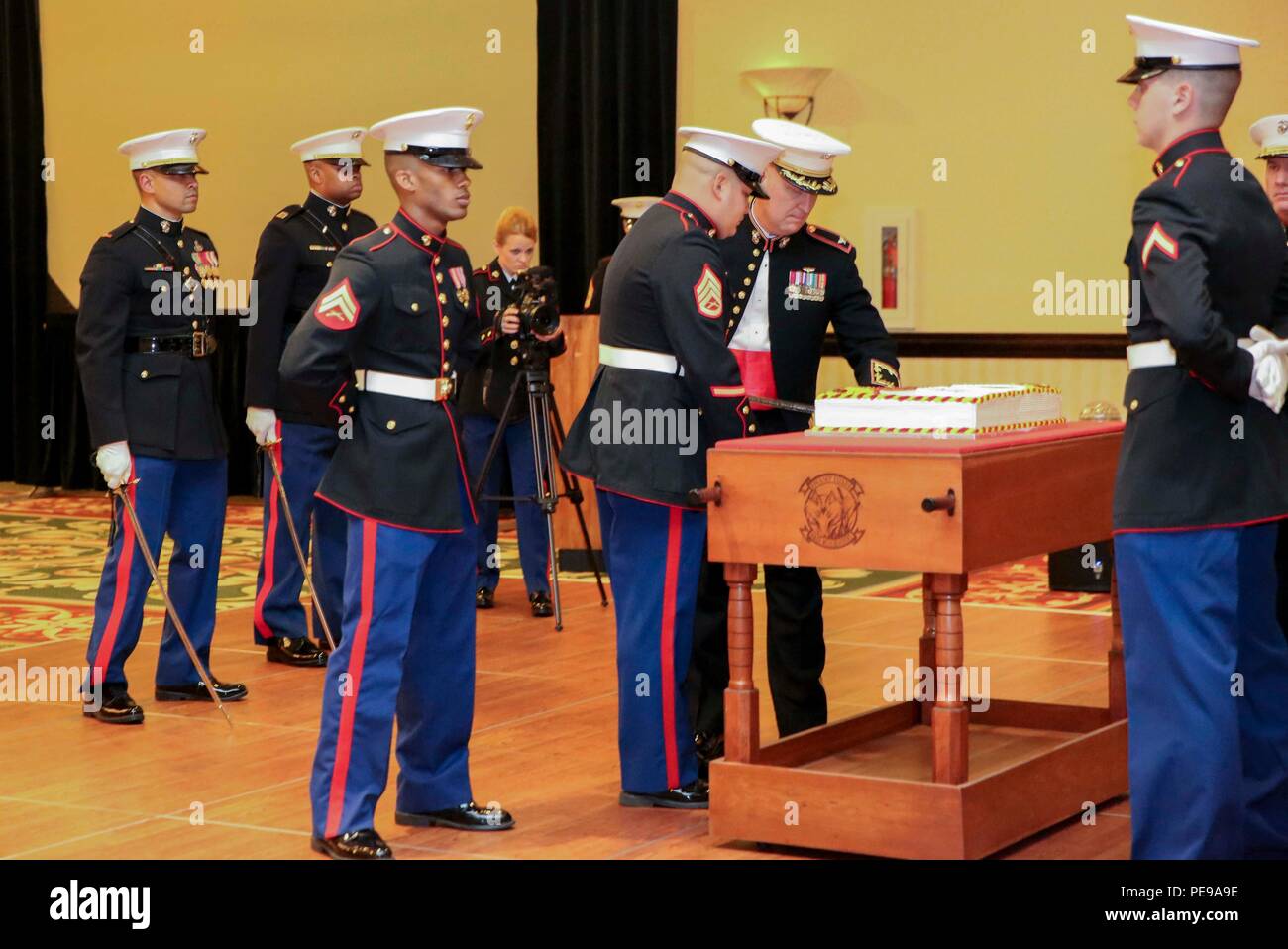 Staff Sgt. Paul J. Miller holds a plate while Col. Peter D. Buck cuts a ...