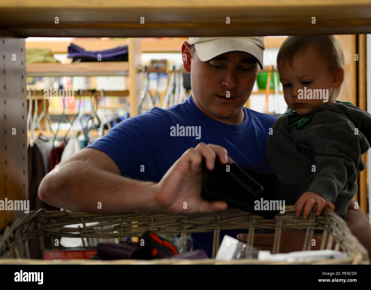 Bryce Stringer and his son, Calum, 1, look through shelves in the ...