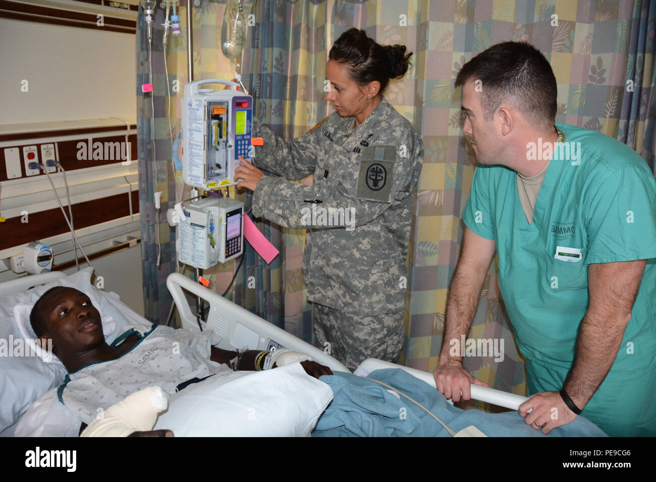 Capt. Kelly Elmlinger, an Army nurse, checks on patient Papa Ndiaye ...