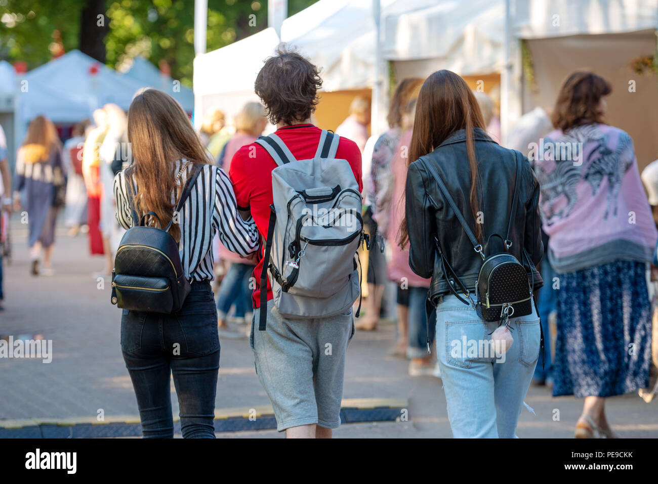 Young people walking along the street with backpacks Stock Photo - Alamy