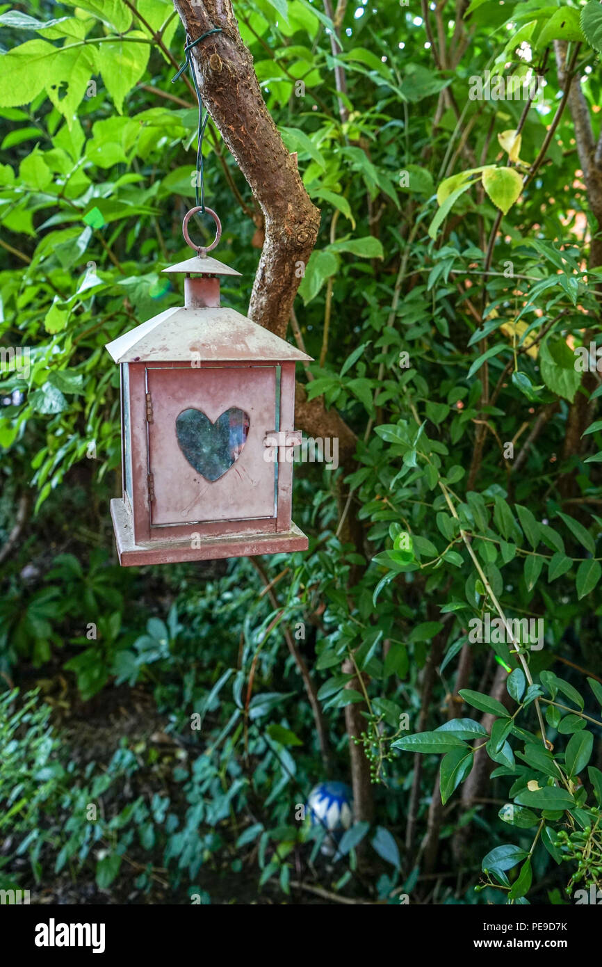 lovely garden scene with small object hanging from tree Stock Photo - Alamy