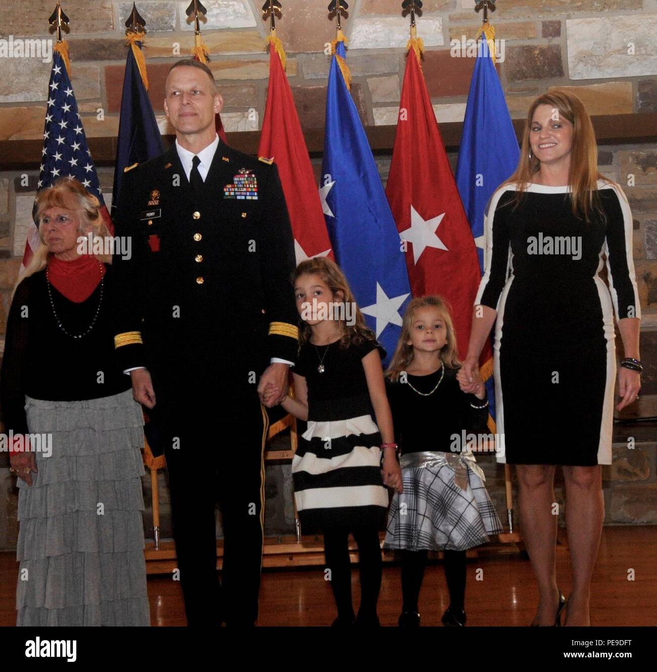 Col. Scott Perry with his mother, wife and children stand before a ...