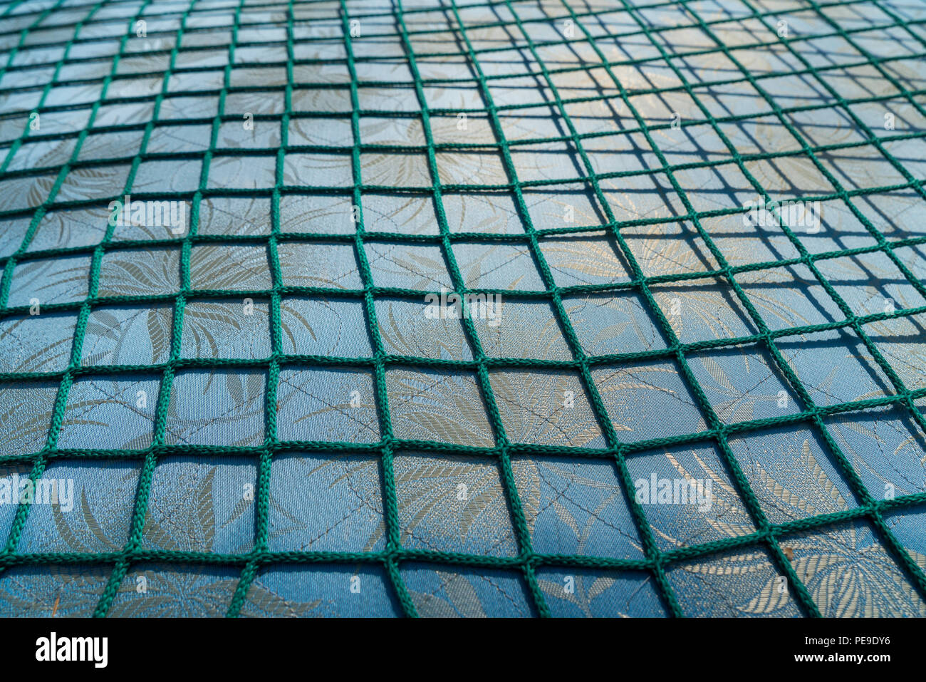 green net over a fabric pattern for backgrounds Stock Photo - Alamy