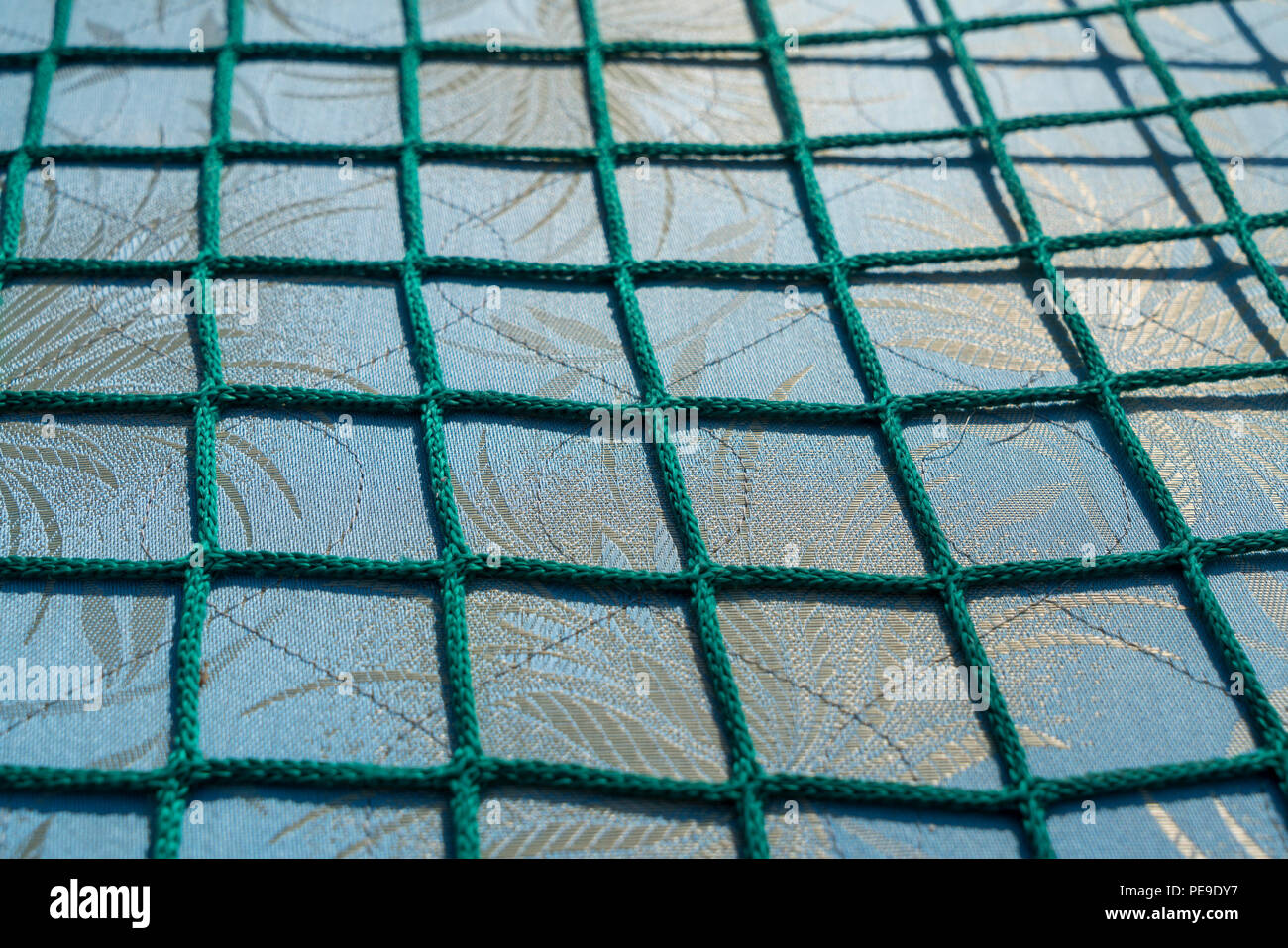 green net over a fabric pattern for backgrounds Stock Photo - Alamy