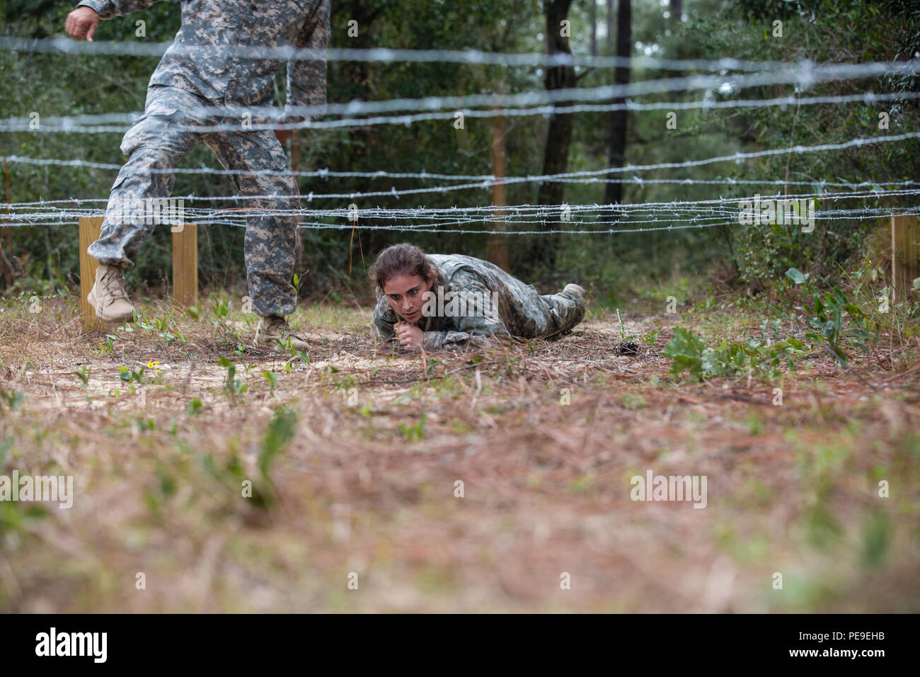 An Army Junior Officer Training Corps cadet low-crawls underneath a ...