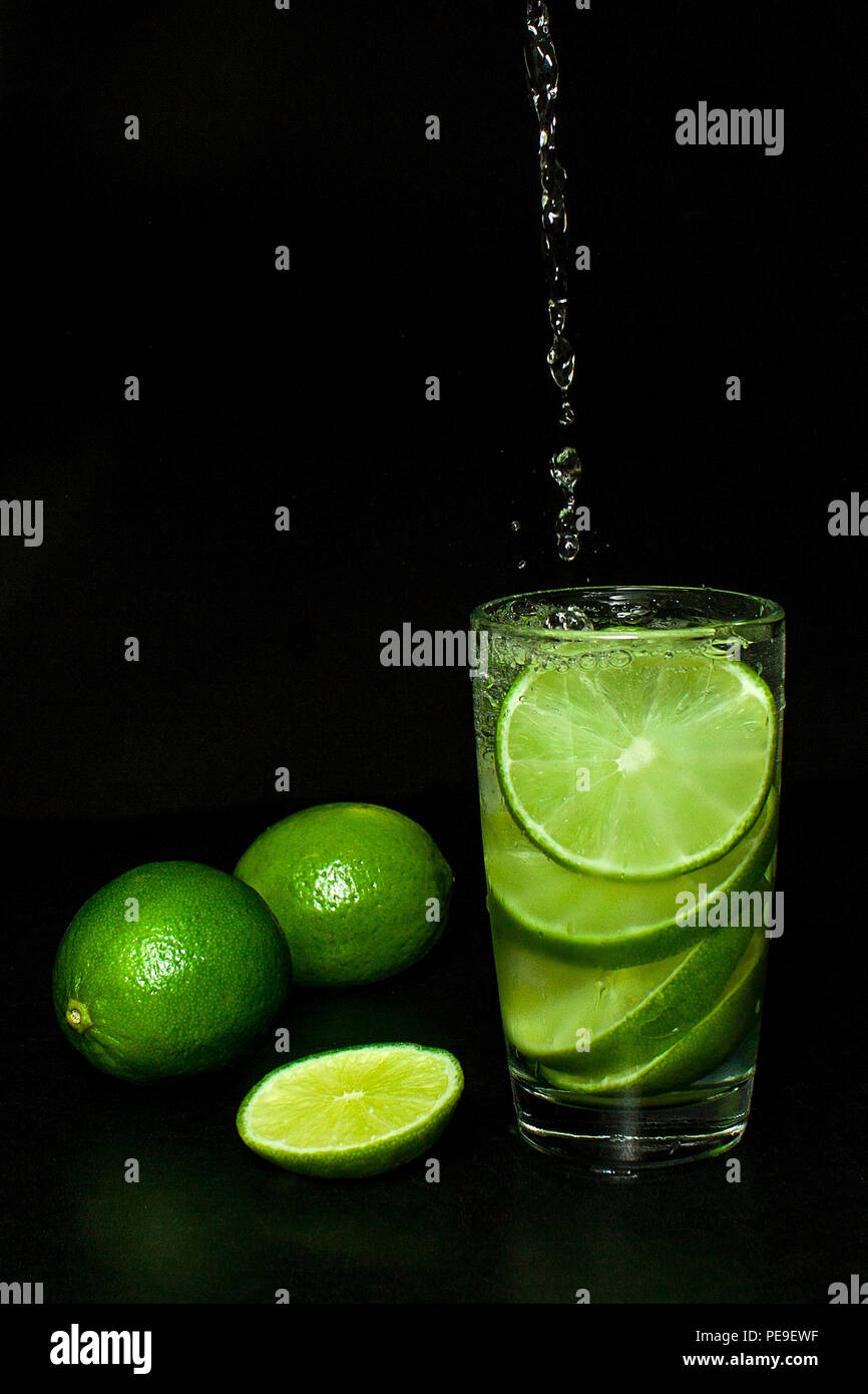 Summer refreshing and beverages concept. Stream of water is poured into ...