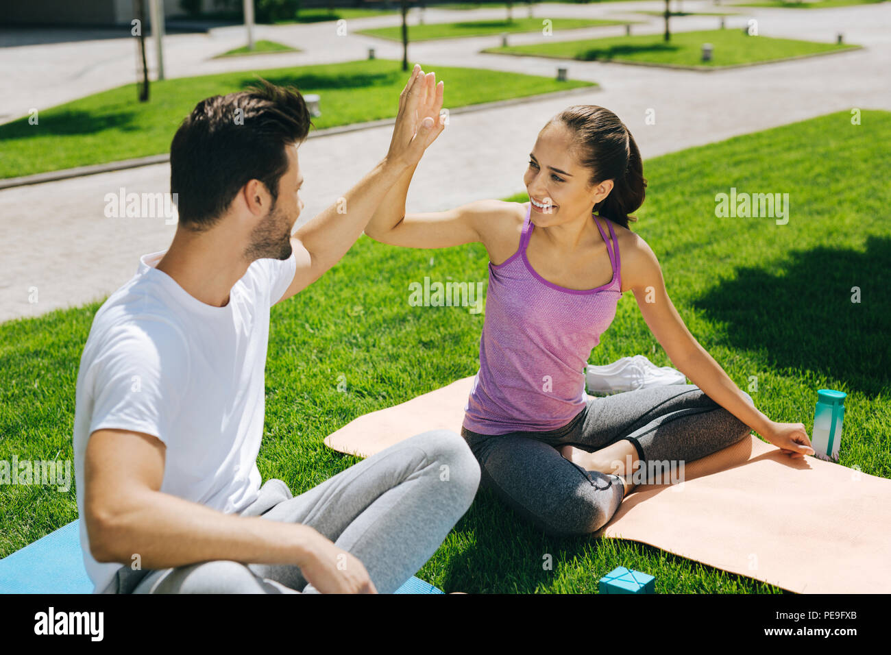 Cheerful positive couple giving high five to each other Stock Photo - Alamy