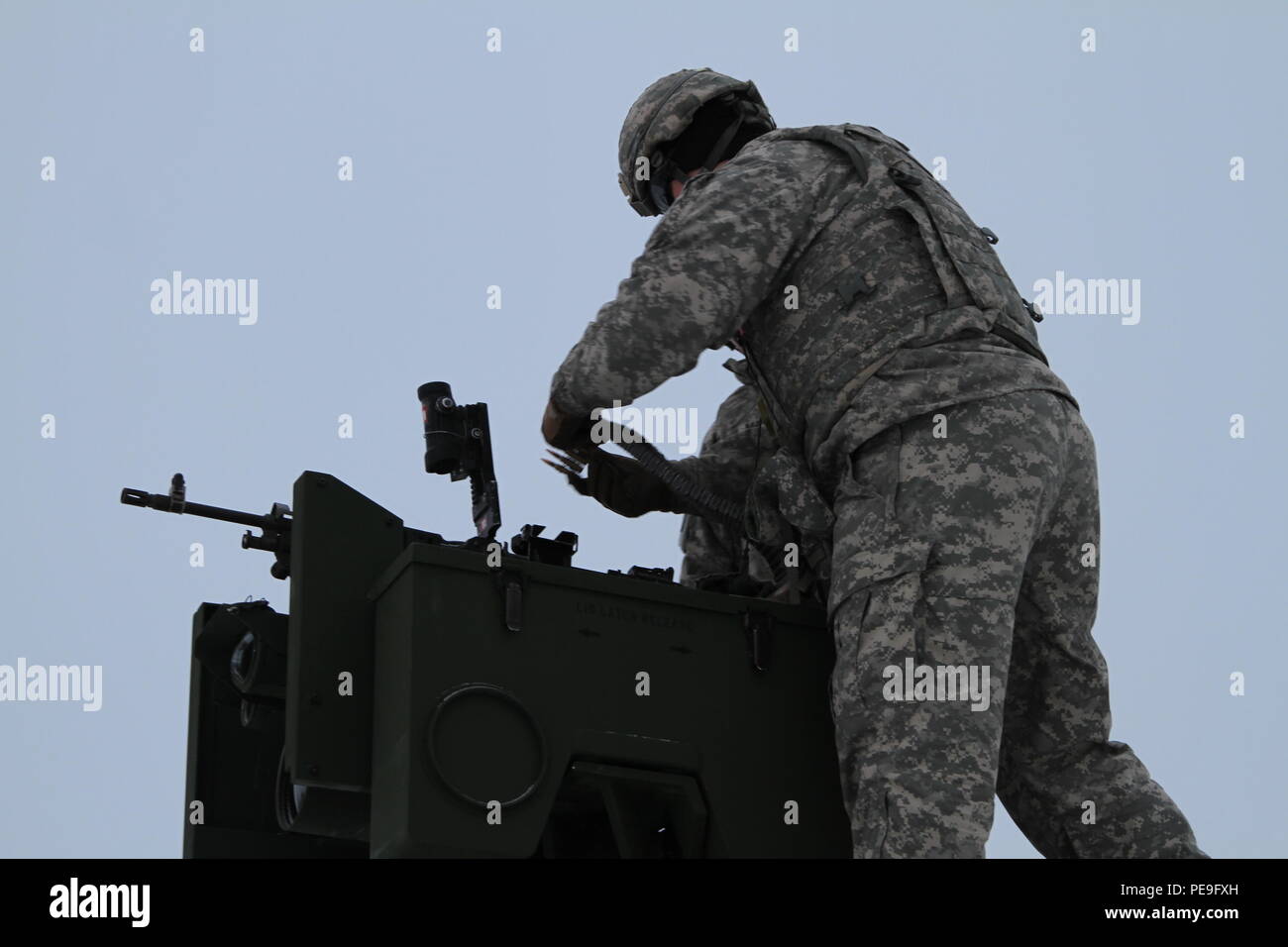 A Soldier loads 7.62 mm rounds into the M240 that's mounted to the ...