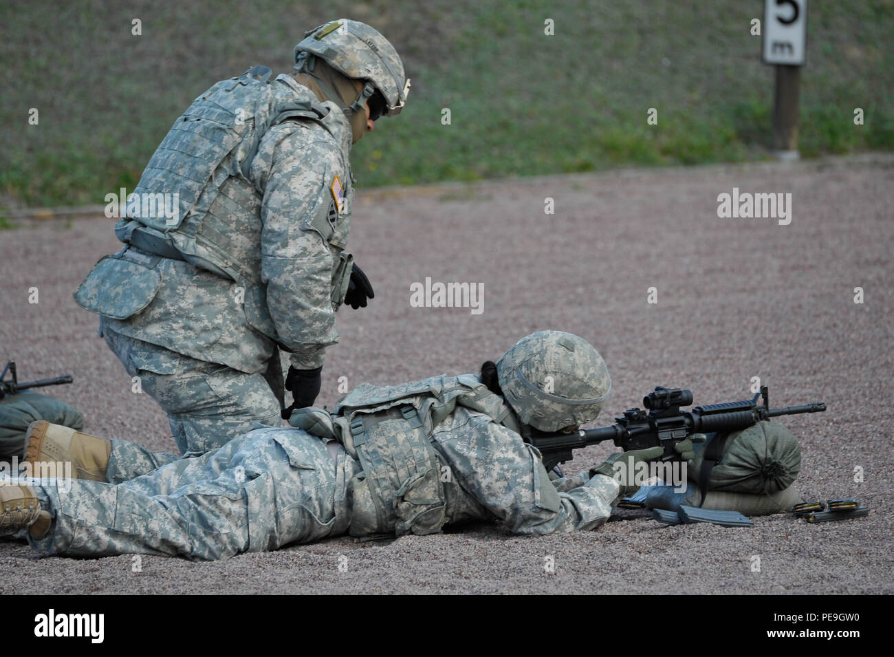 A U.S. Soldier serving as a firing coach, left, observes the technique ...