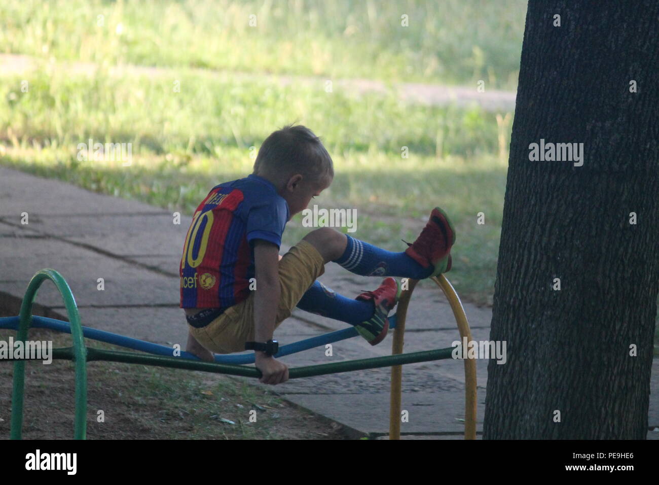 little boy in football form made moring exercise on the playground in ...