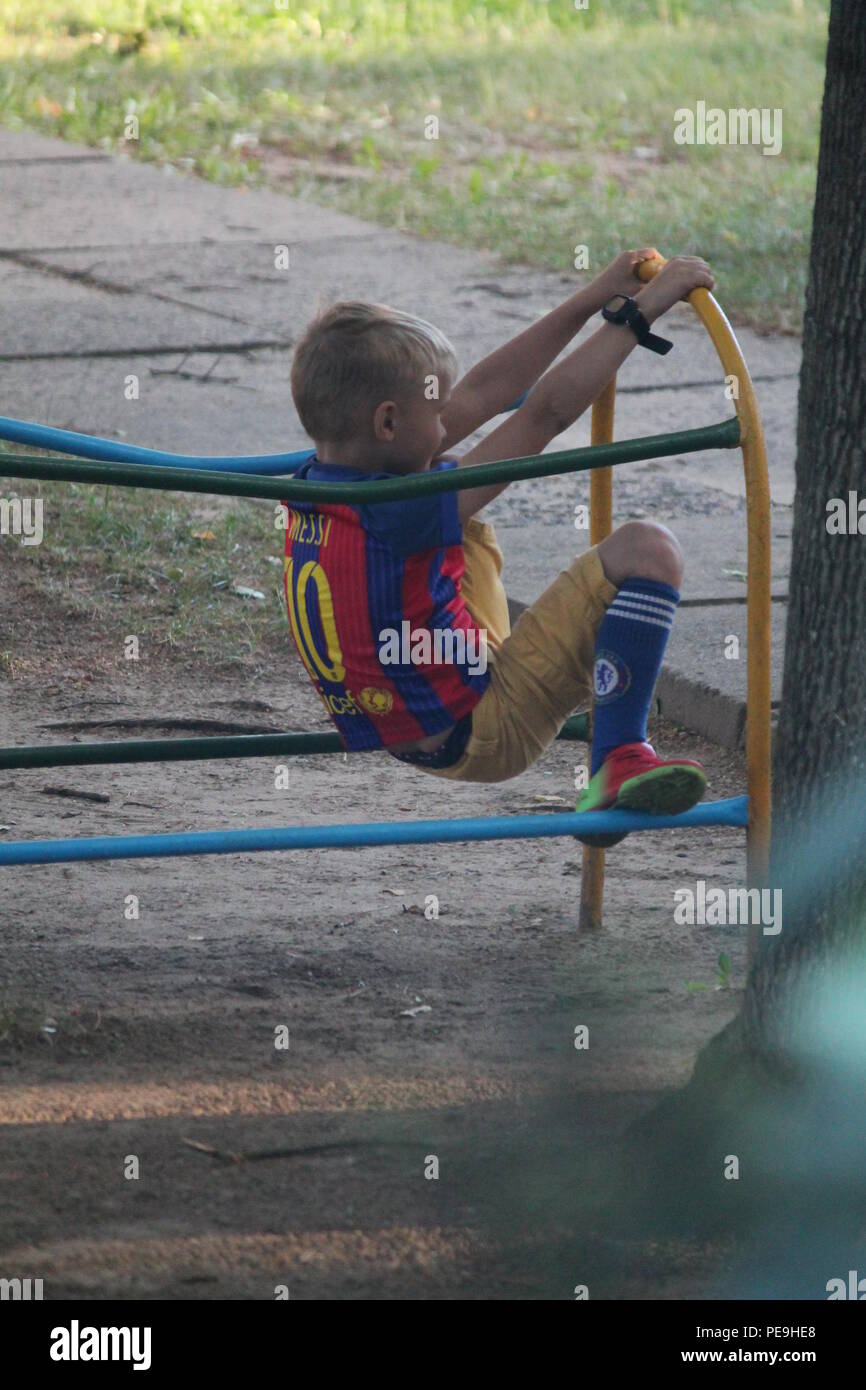 little boy in football form made moring exercise on the playground in ...