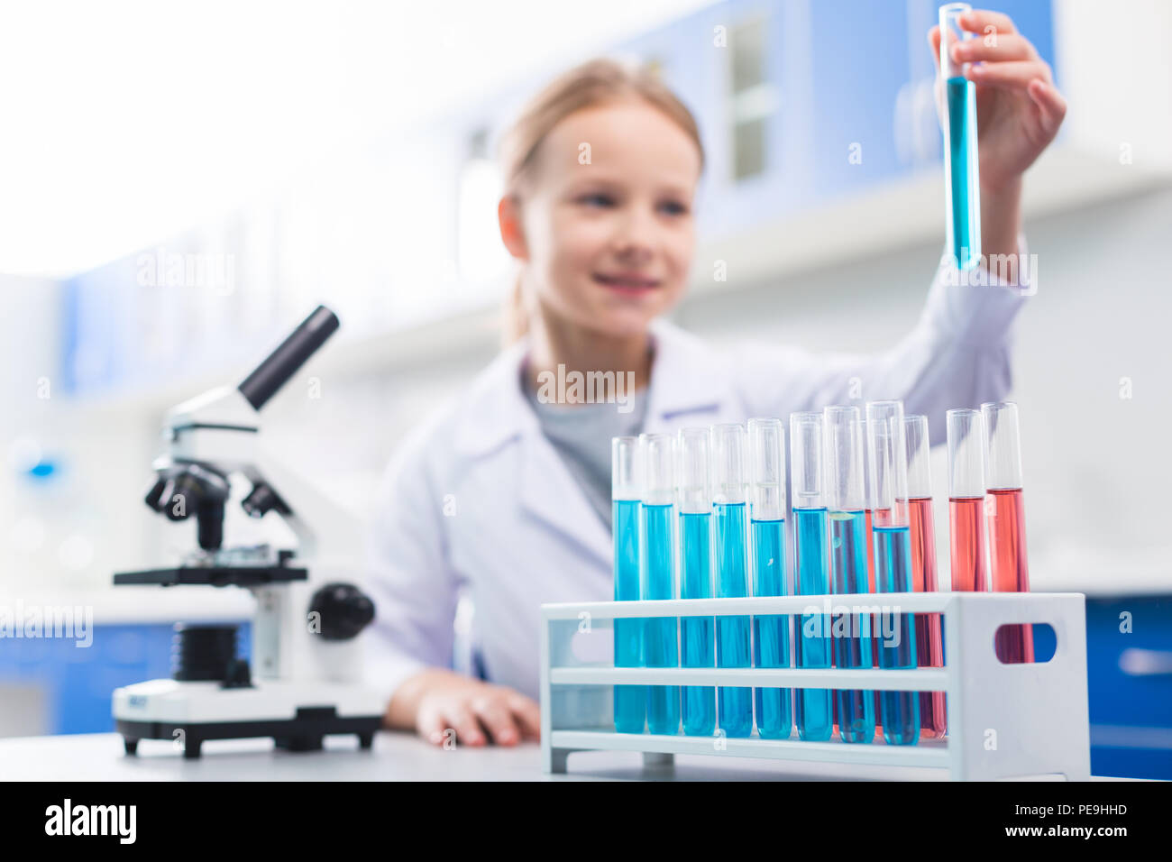 Blue reagent. Selective focus of glass small transparent vials putting ...