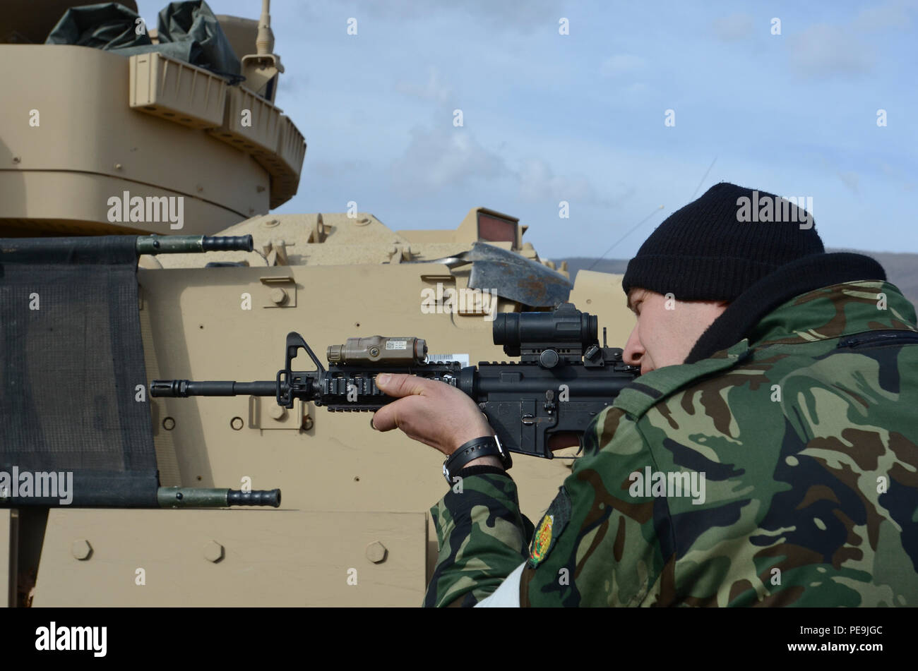 A Bulgarian soldier looks through an Advanced Combat Optical Gunsight ...