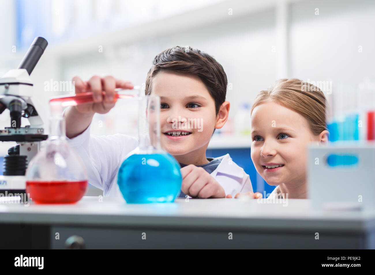 Reckless behavior. Joyful jolly merry kids staring at laboratory ...