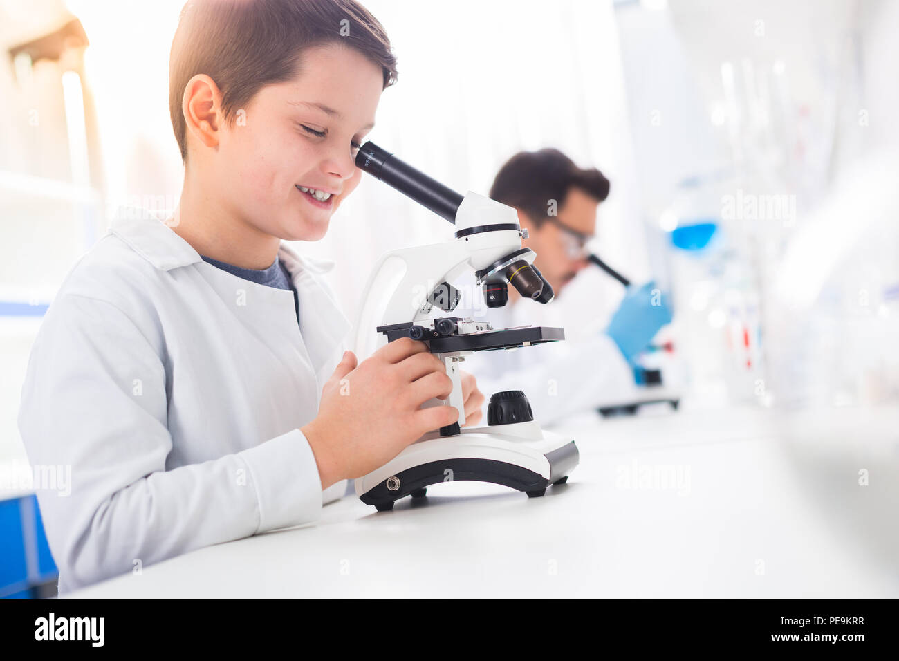 Future laboratorian. Low angle of cute attractive sweet boy using ...