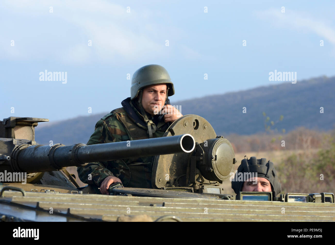 Bulgarian soldiers of 1-61st Mechanized Battalion look out the hatches ...