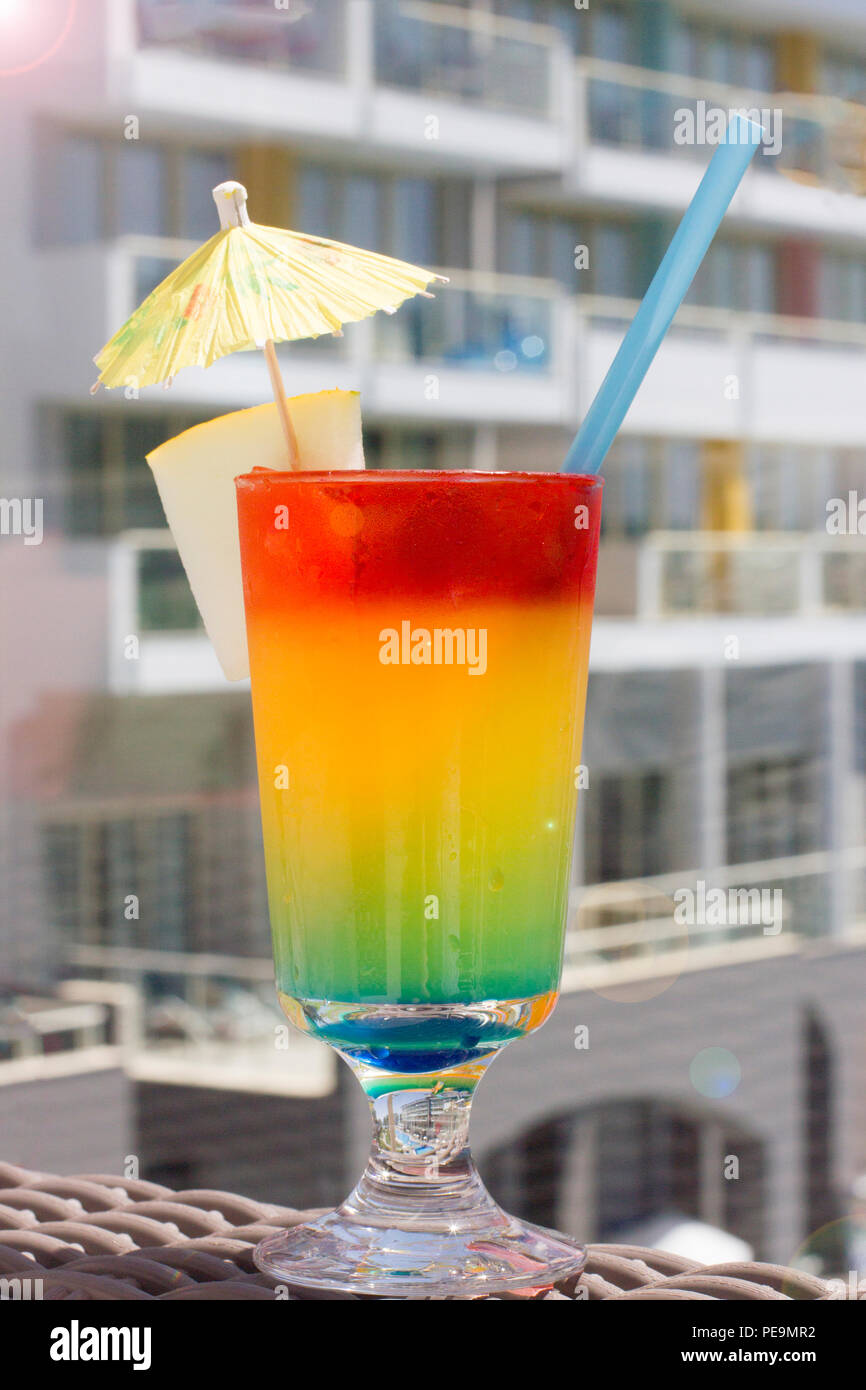 Bright cocktail with umbrella on a bench Stock Photo - Alamy
