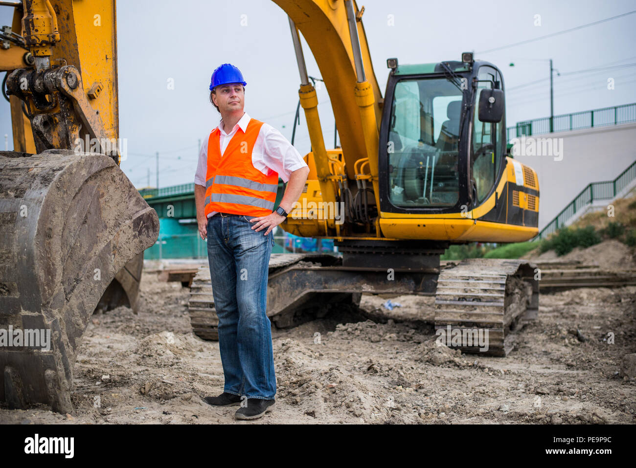 Engineer in front of excavator on a construction site Stock Photo - Alamy