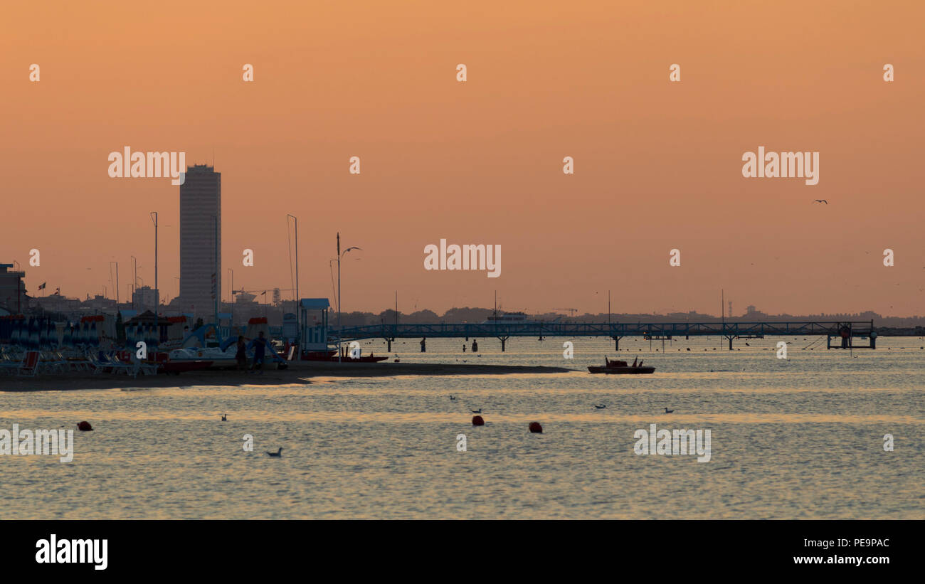 Colorful sunset reflected on water beach, italy Stock Photo - Alamy