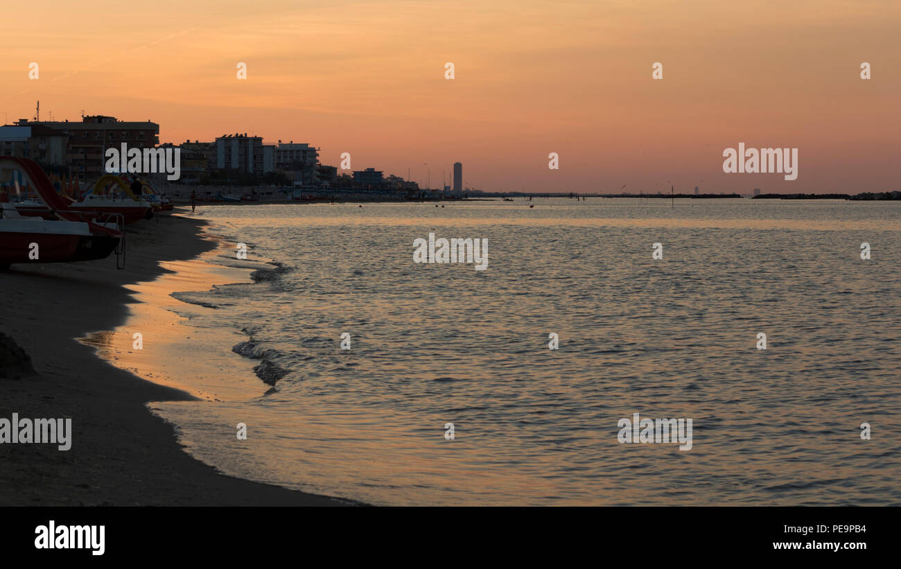 Colorful sunset reflected on water beach, italy Stock Photo - Alamy