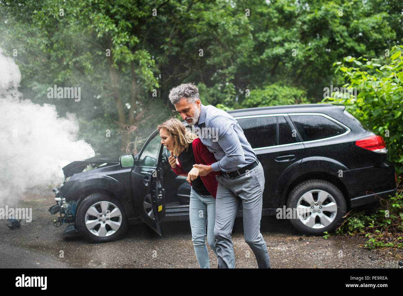 A mature man helping a young woman to walk after a car accident Stock ...