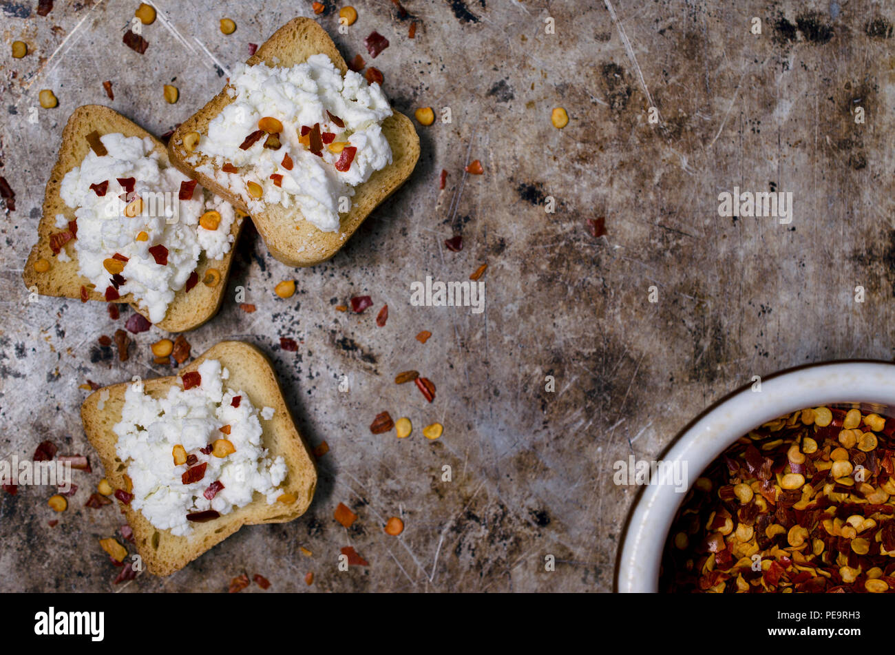 Flat lay photograph of miniature toast topped with white cheese and red ...