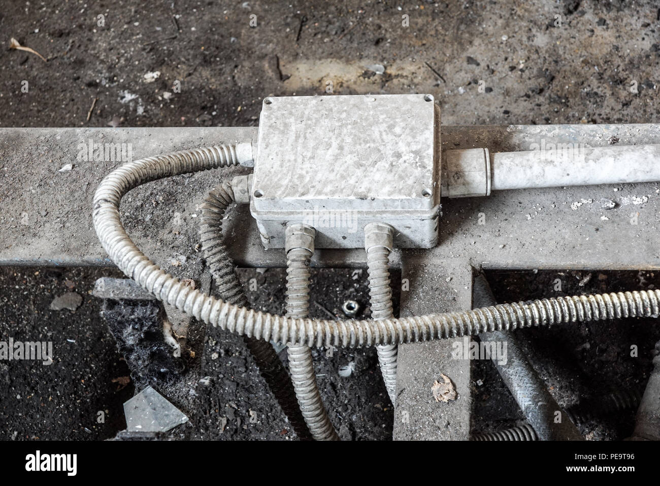 White electric box with three black cables on the old red brick wall ...
