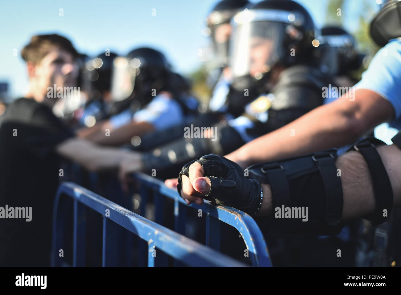 Police officer hands on a security fence during a riot Stock Photo - Alamy