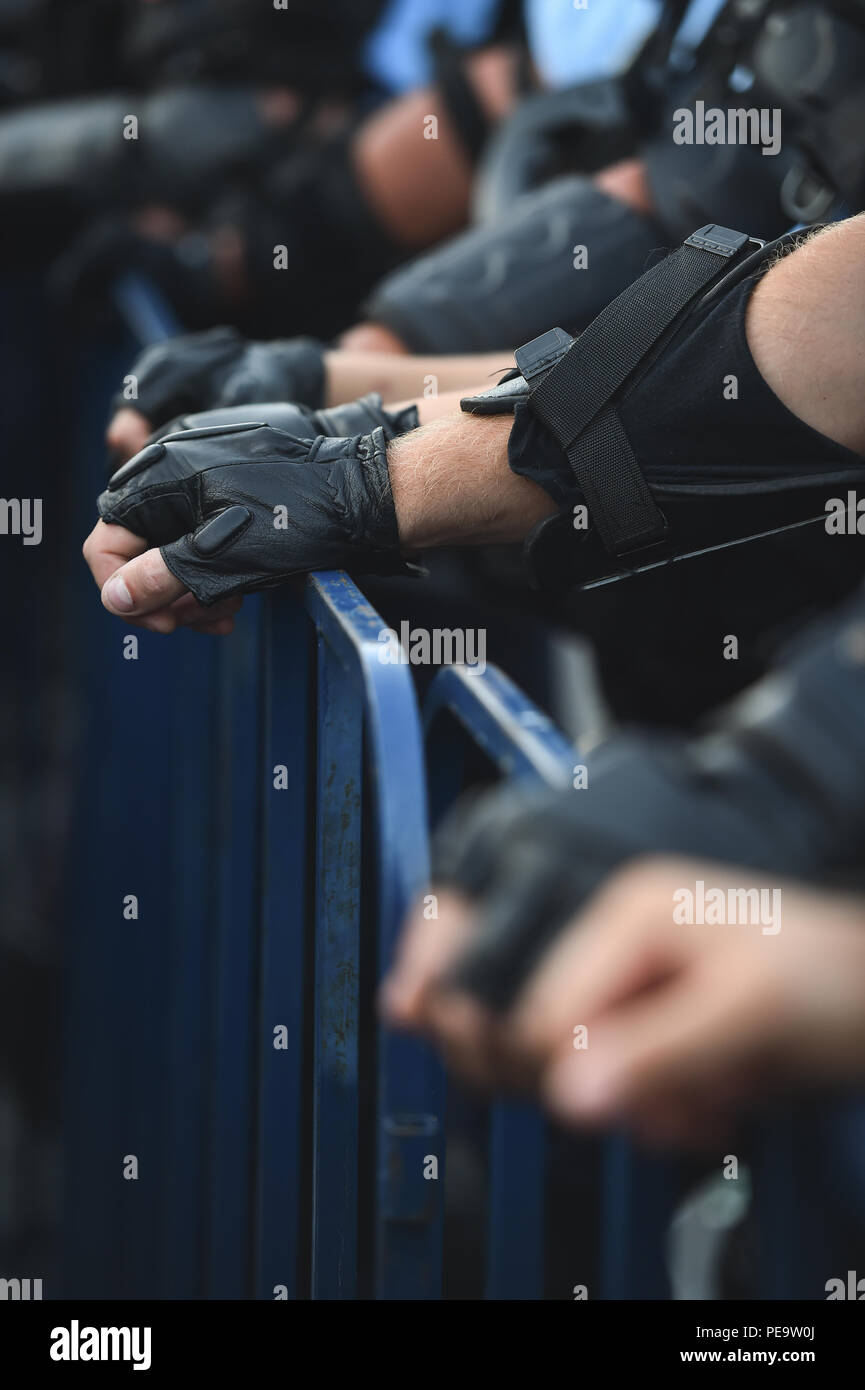 Police officer hands on a security fence during a riot Stock Photo - Alamy