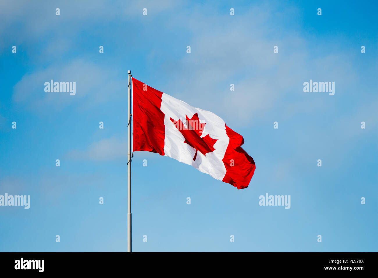 Blue skies with a canadian maple leaf flag in the wind Stock Photo - Alamy
