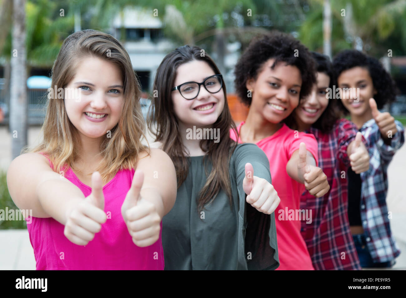 Group of successful international girls standing in line outdoors in ...
