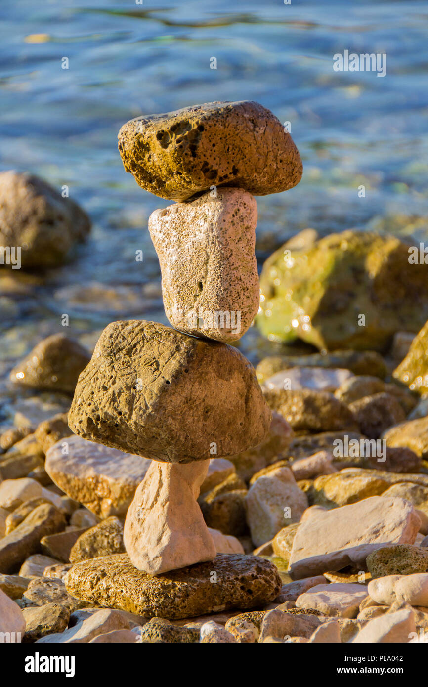 Pyramid of sea stones on pebbles of the sea shore. Seascape. The ...