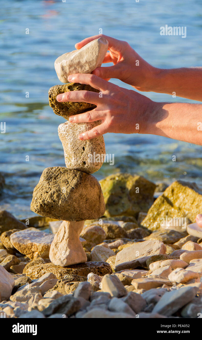 Pyramid of sea stones on pebbles of the sea shore. Seascape. The ...
