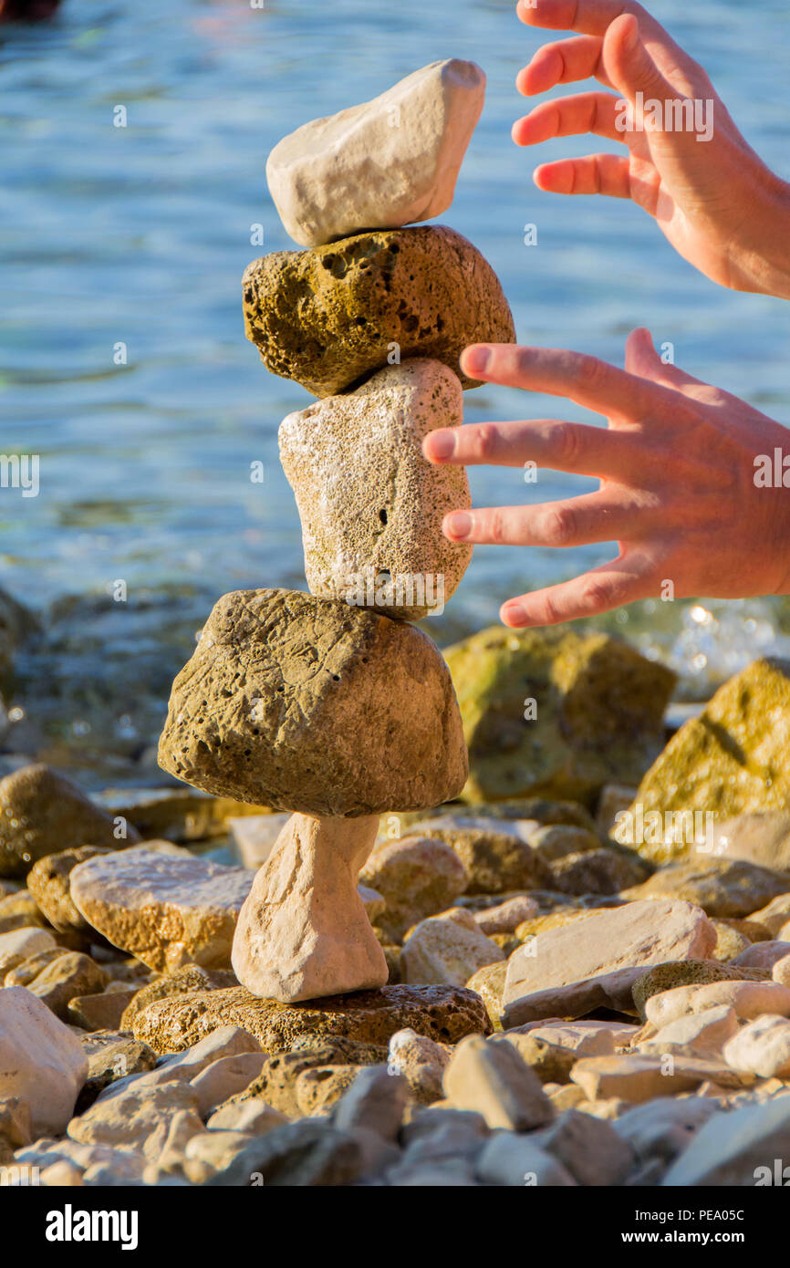 Pyramid of sea stones on pebbles of the sea shore. Seascape. The ...